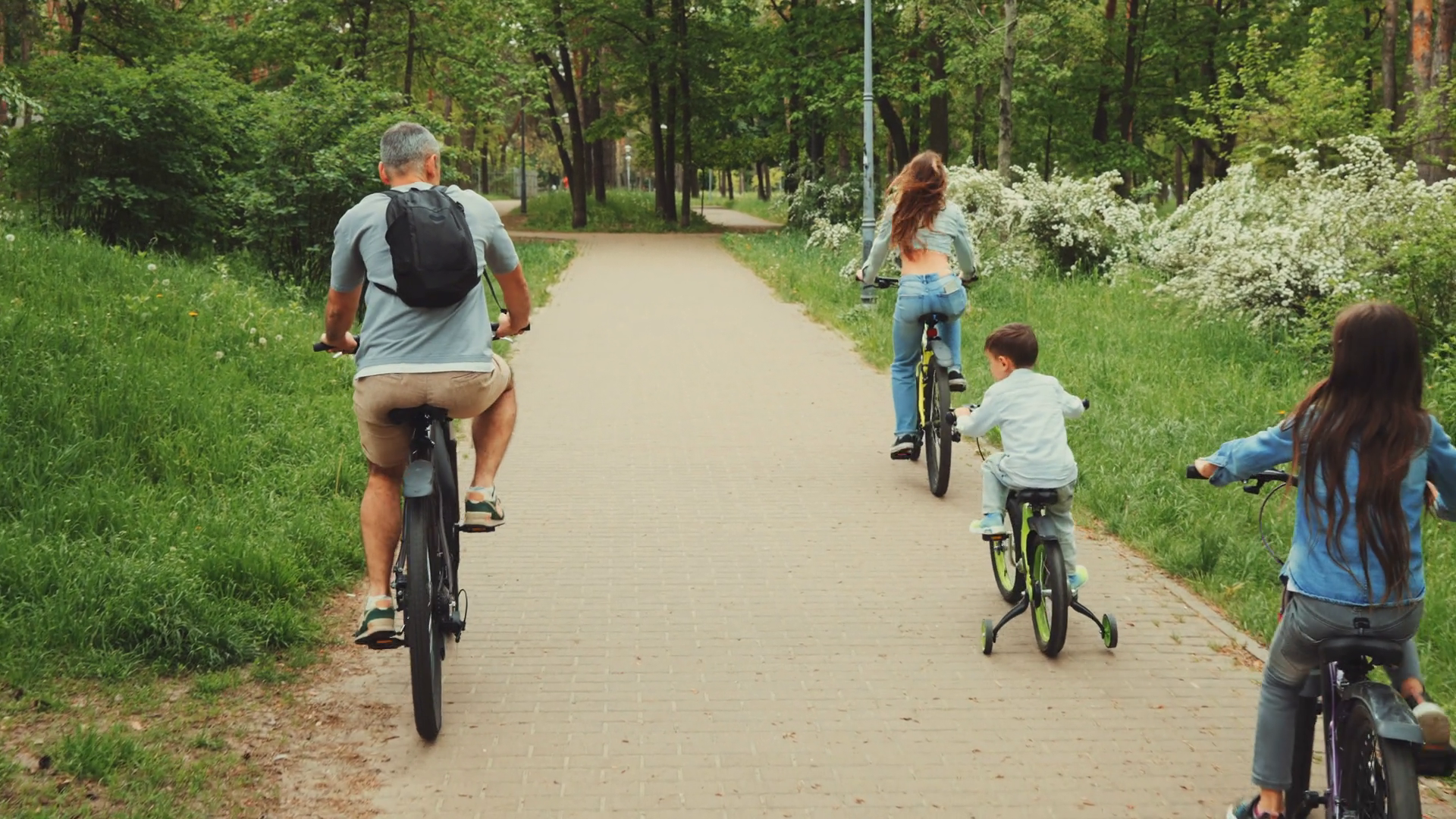 Family Biking Together On Paved Path Through Stock Footage SBV ...