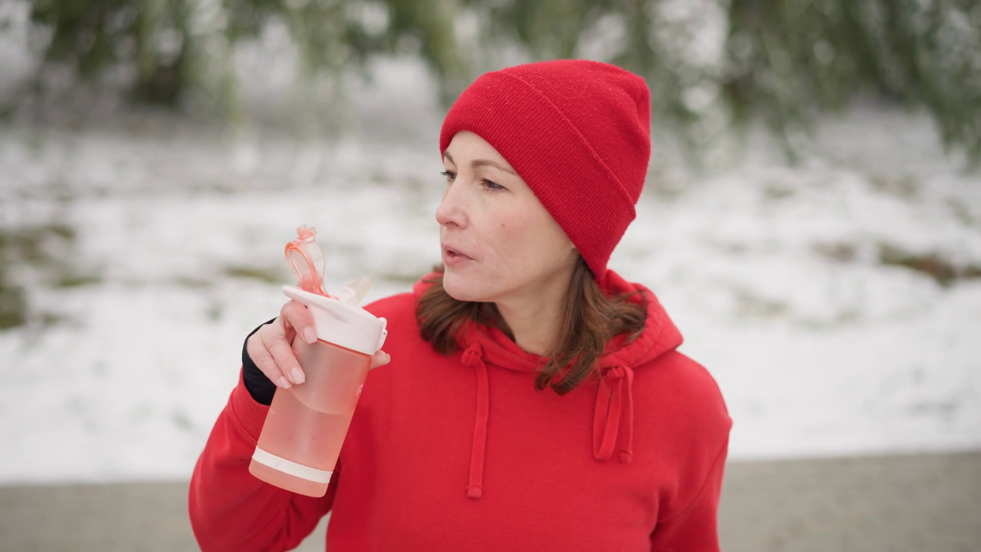 Lady In Red Beanie Hoodie Sipping Water From Stock Footage SBV ...